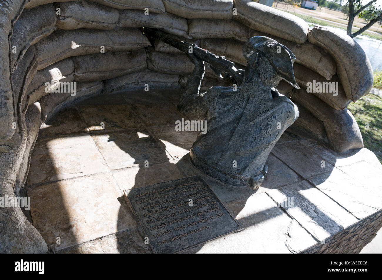 A statue of a 1st World War Australian soldier aiming a rifle behind a ...