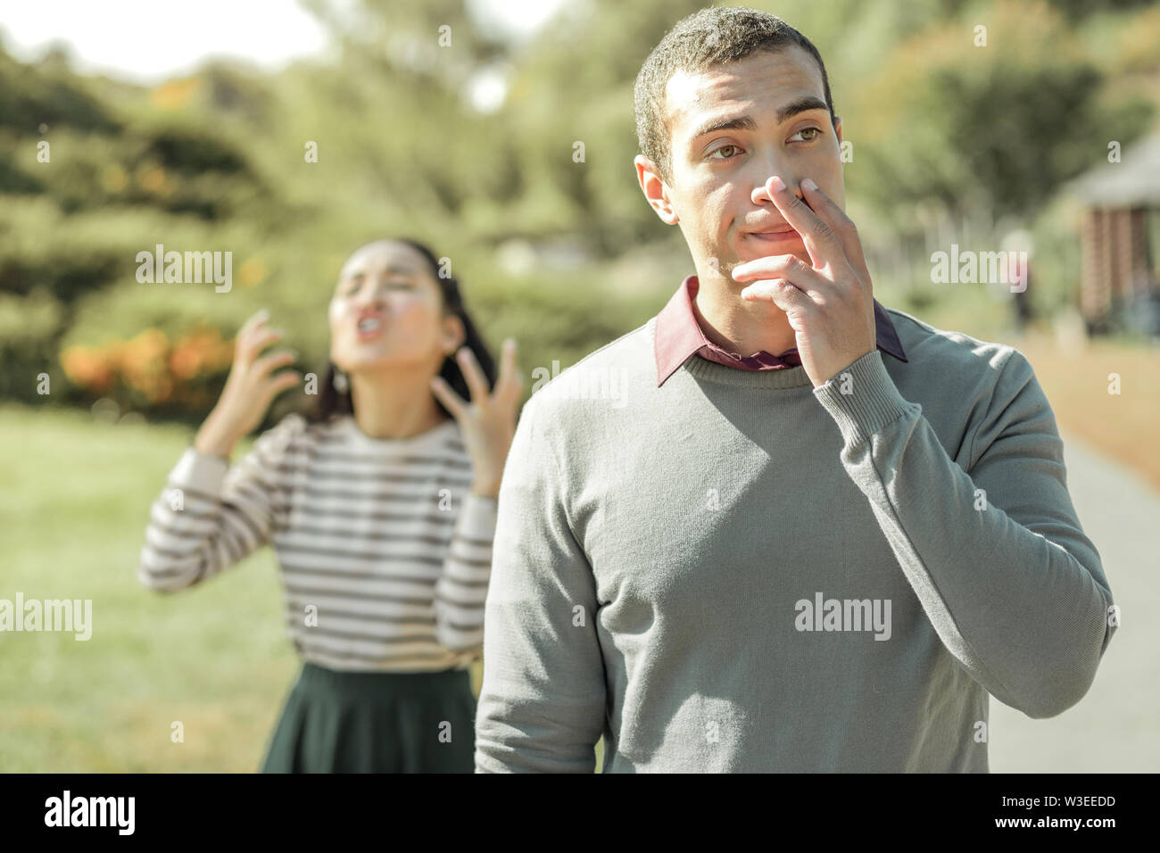 Desperate guy hiding his face while expressive girlfriend Stock Photo ...