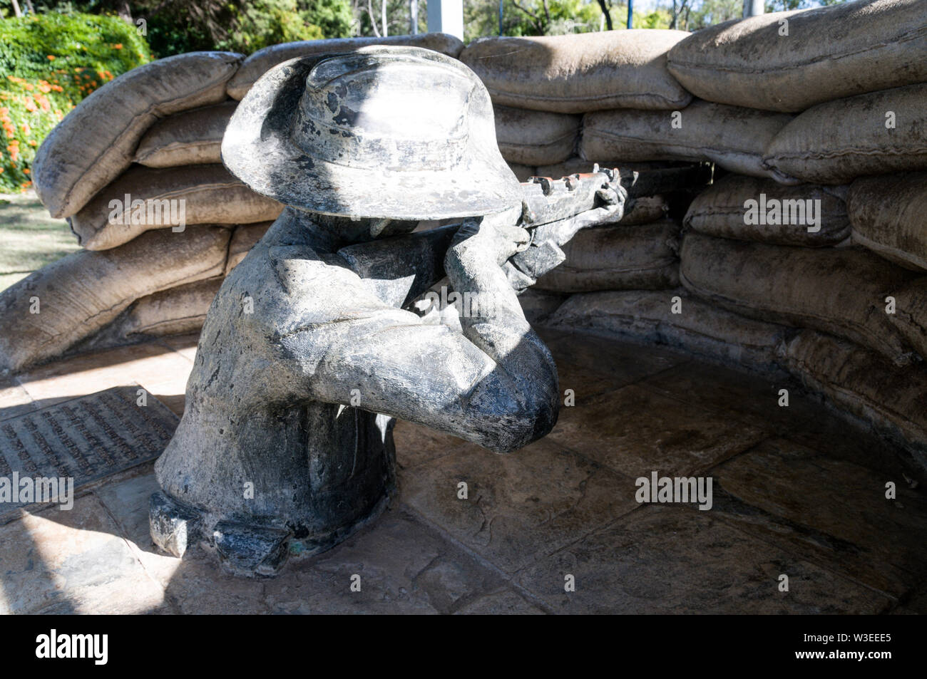 A statue of a 1st World War Australian soldier aiming a rifle behind a ...