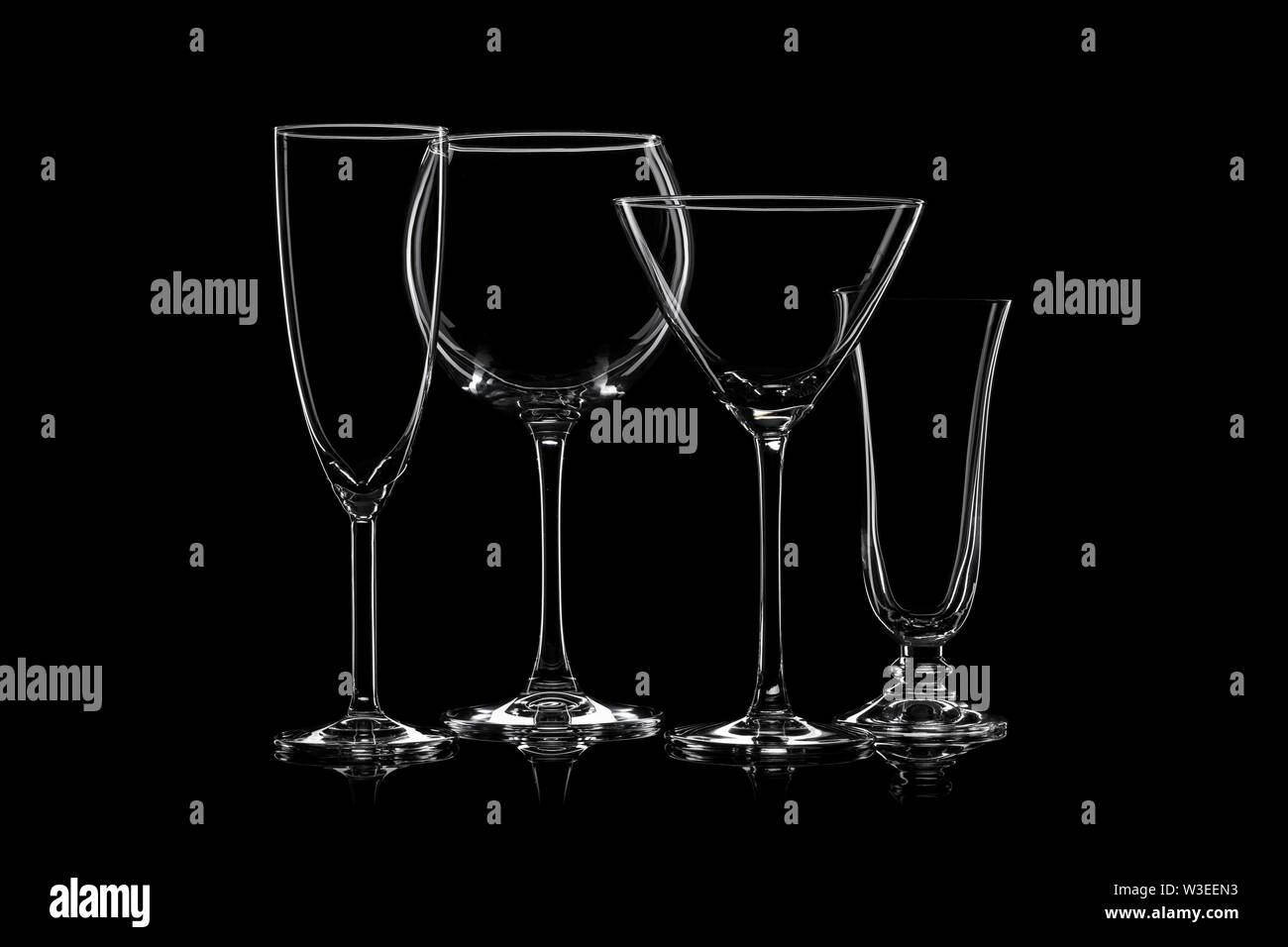 Empty cocktail glassware on a black background Stock Photo - Alamy