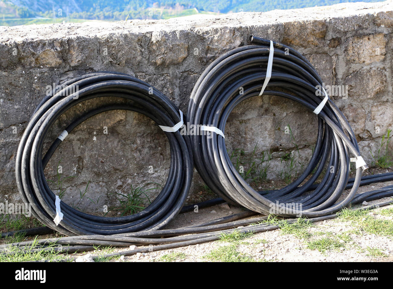 The electric cable in the roll stands against the wall Stock Photo - Alamy