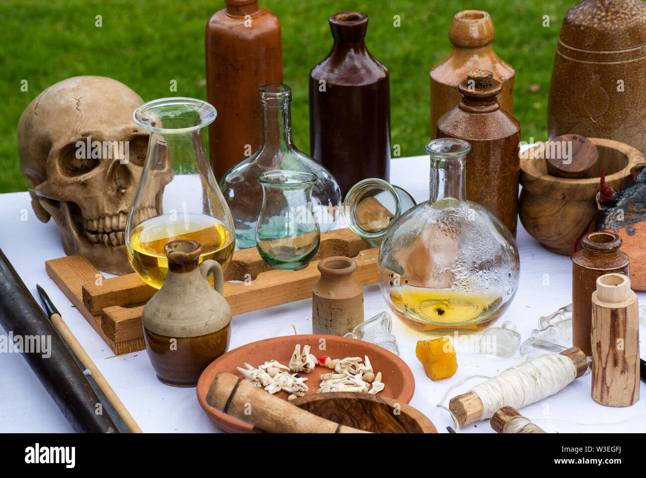 Medieval apothecary's table with bottles jars and skull Stock Photo - Alamy