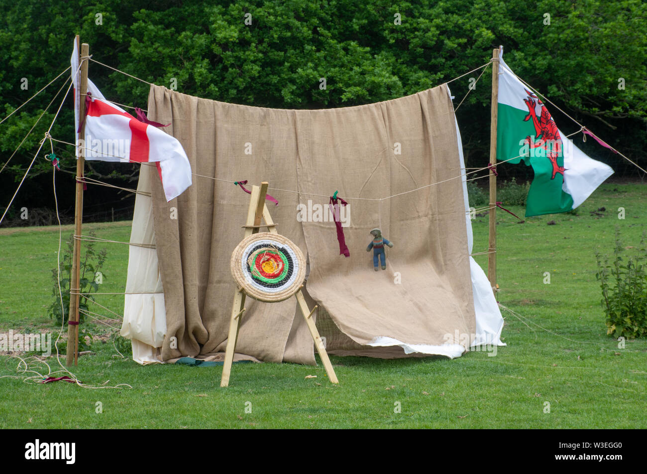 Medieval archery target board in field with welsh flag and george cross ...