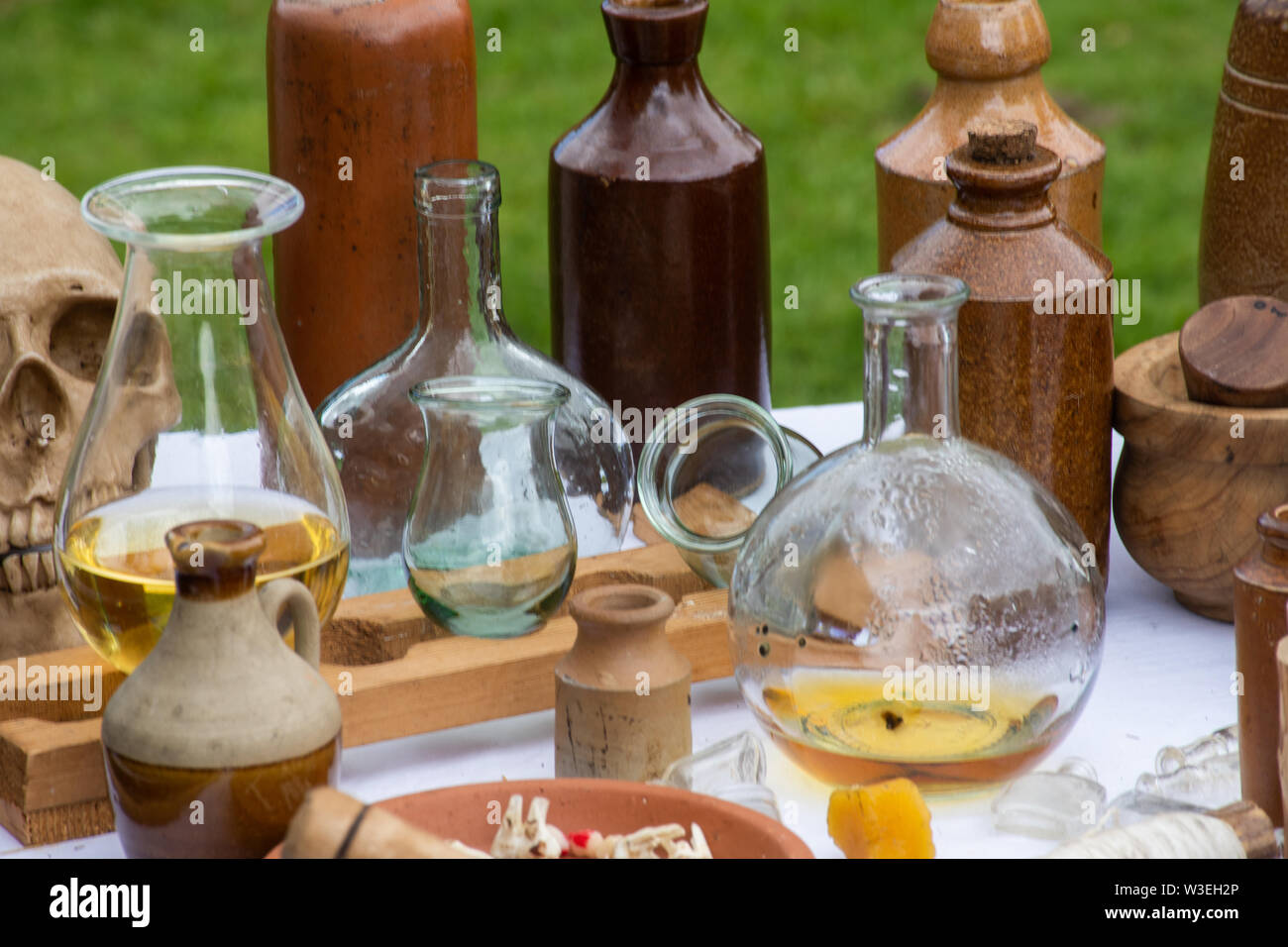 Table of medieval apothecary with bottles and jars Stock Photo - Alamy