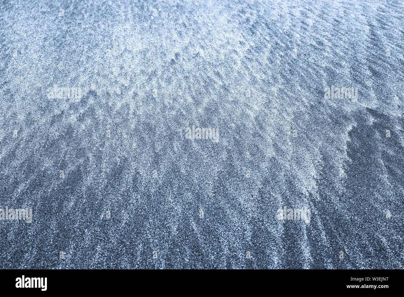 Close-up of Sand patterns and a stone on the beach with ripples in a ...