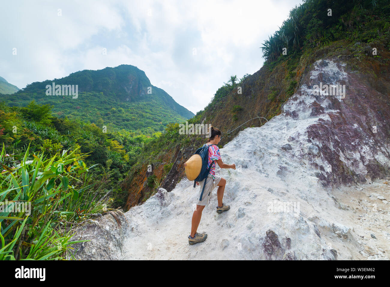 One tourist climbing Sibayak volcano, active caldera steaming, famous ...