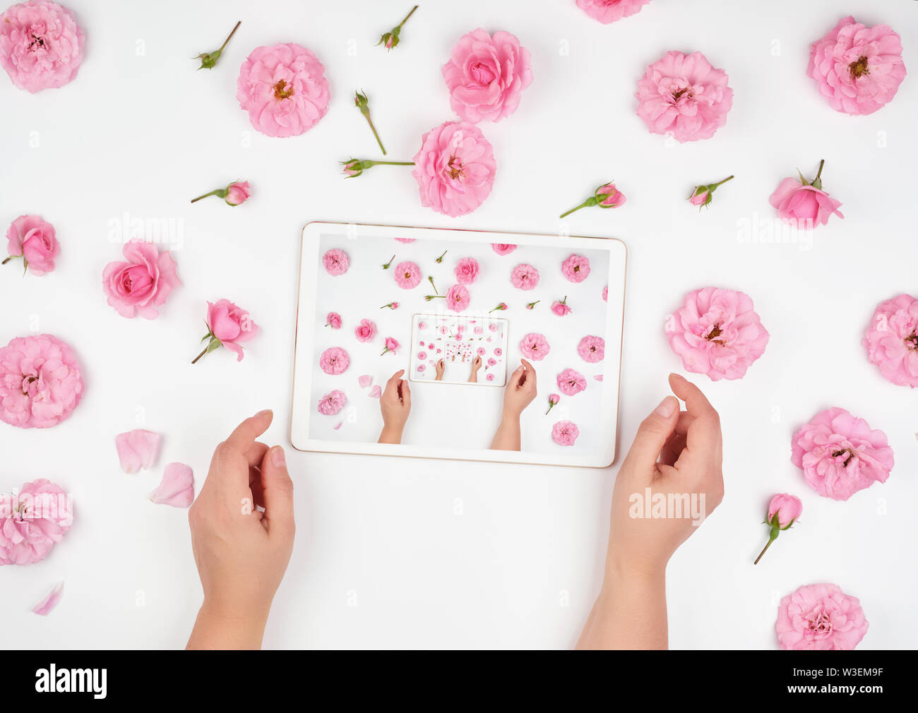 white electronic tablet with a blank black screen and two female hands ...