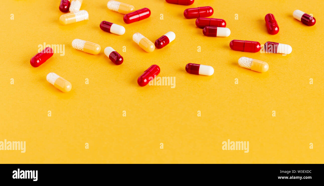 Scattered yellow and red drug capsules with active microgranules Stock ...