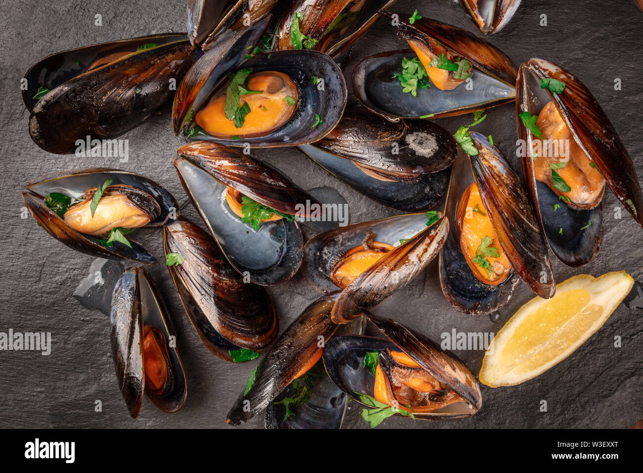 Marinara mussels, moules mariniere, with lemon slices, overhead close ...