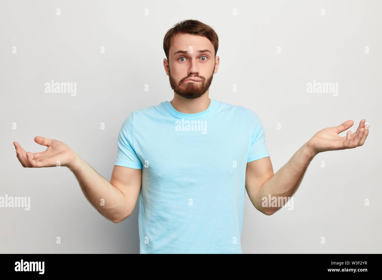 Clueless puzzled funny man with widely opened eyes having hesitation ...