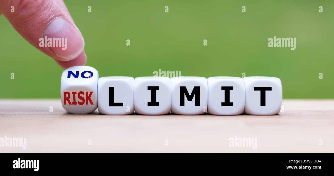 Hand turns a dice and changes the expression "RISK LIMIT" to "NO LIMIT ...