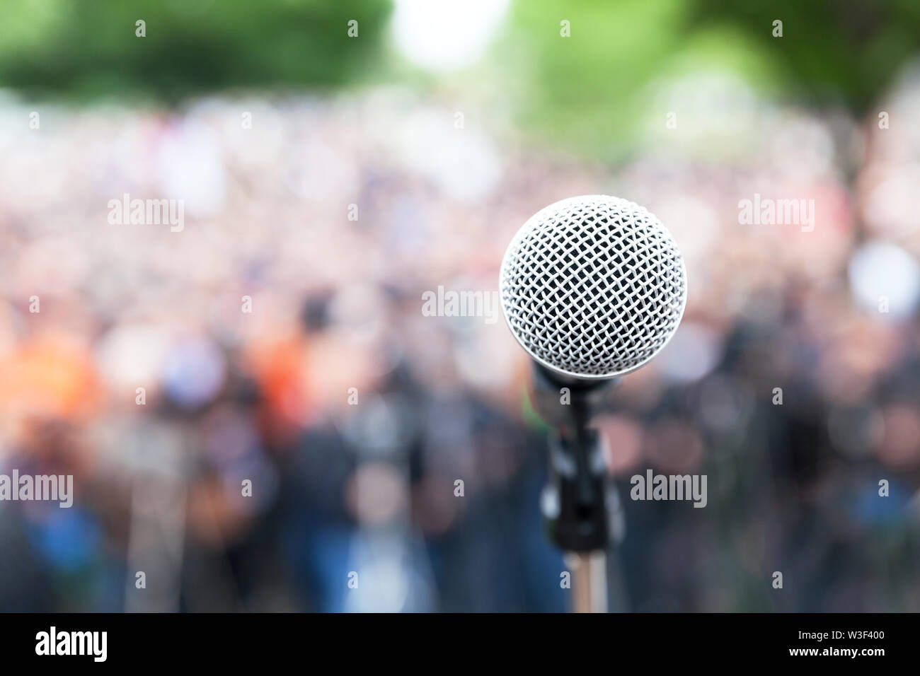 Microphone in focus against blurred crowd Stock Photo - Alamy