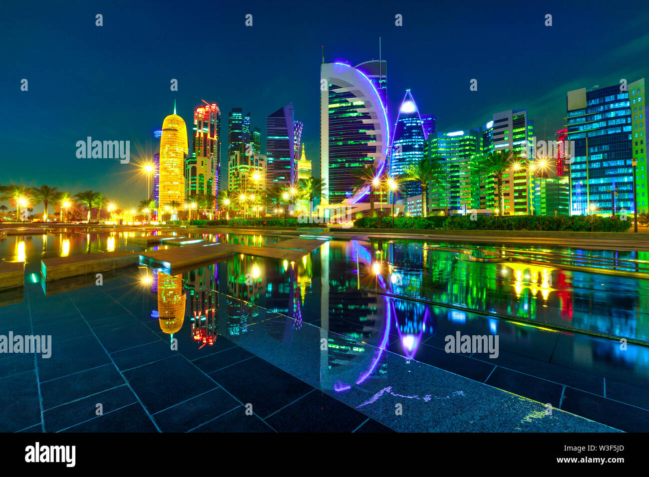 The colorful towers of Doha West Bay reflection by night. Evening ...