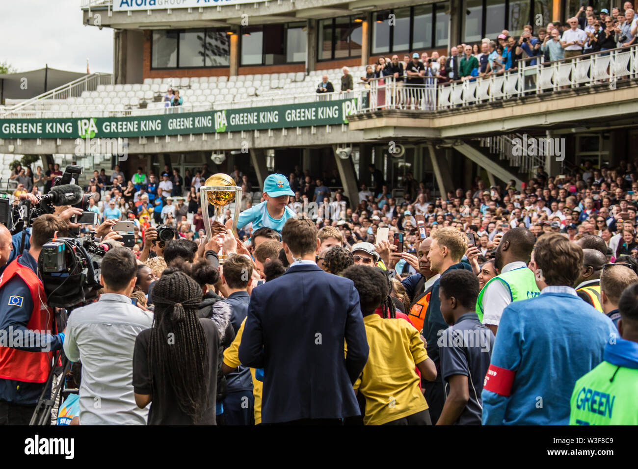 London, UK. 15 July, 2019. The ICC trophy aloft in the crowd as England ...