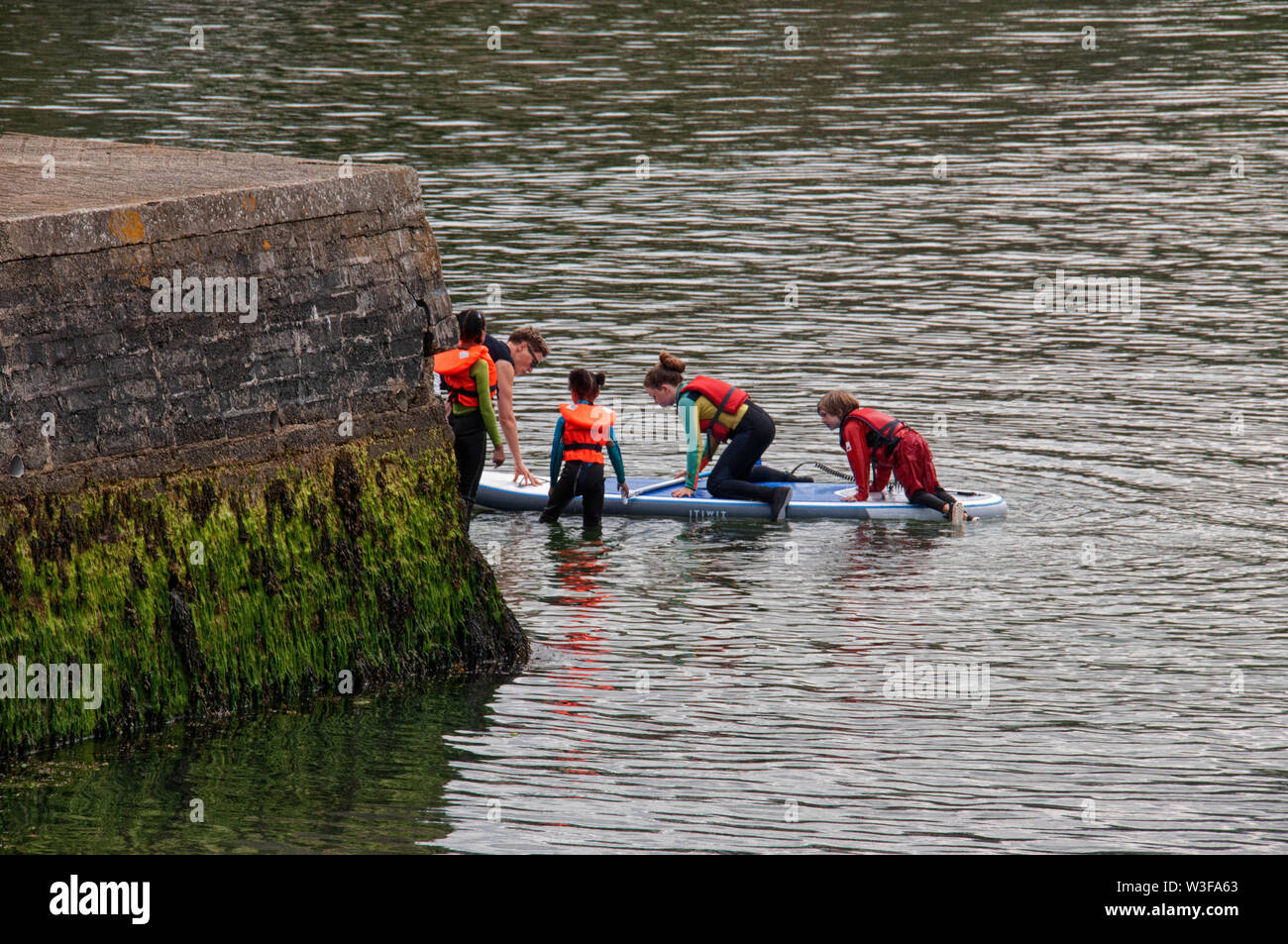 A group of girls paddle boarding in Wicklow Harbour on the Irish coast ...