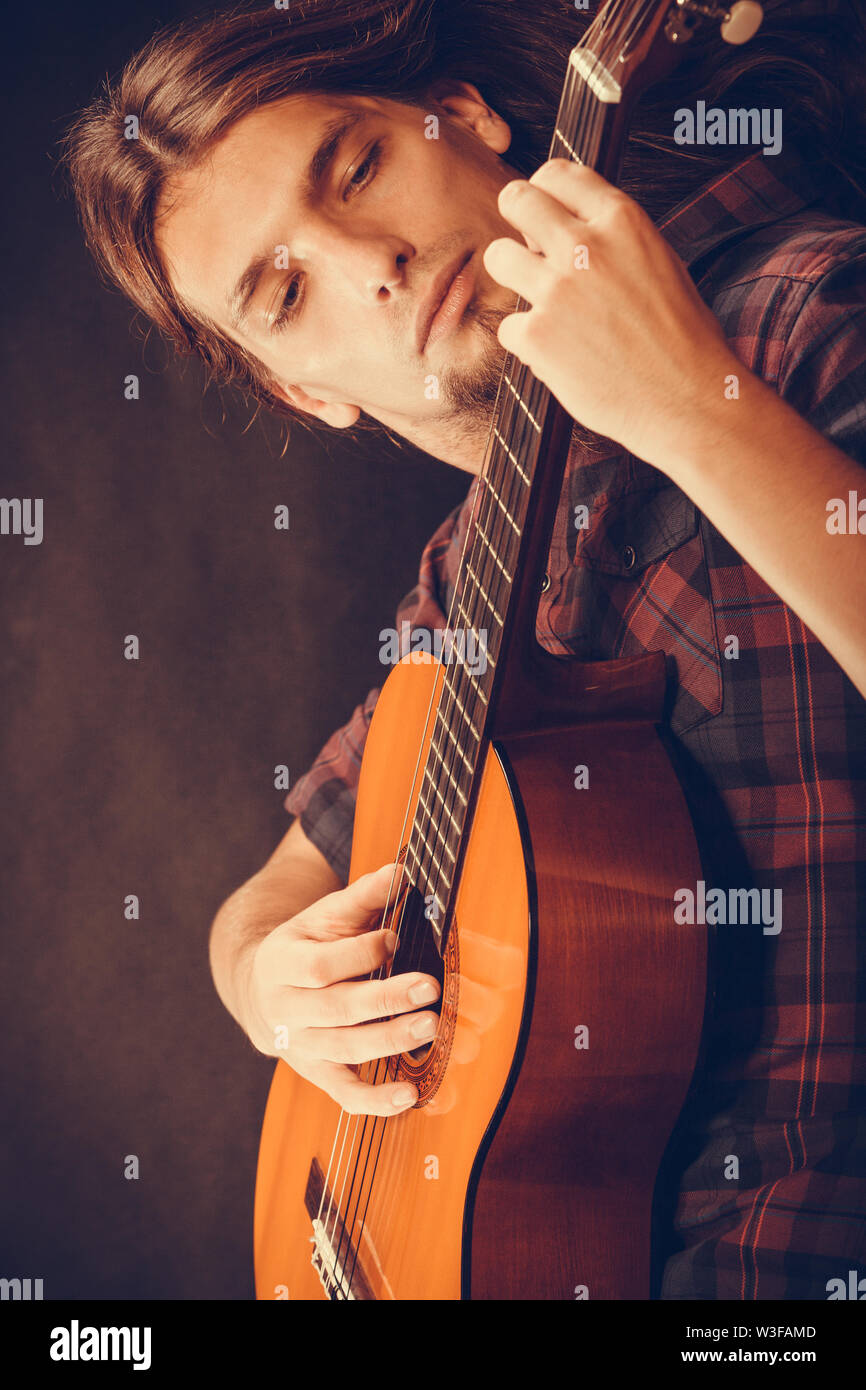 Music, hobby concept. Focused hippie with his guitar. Holding the ...