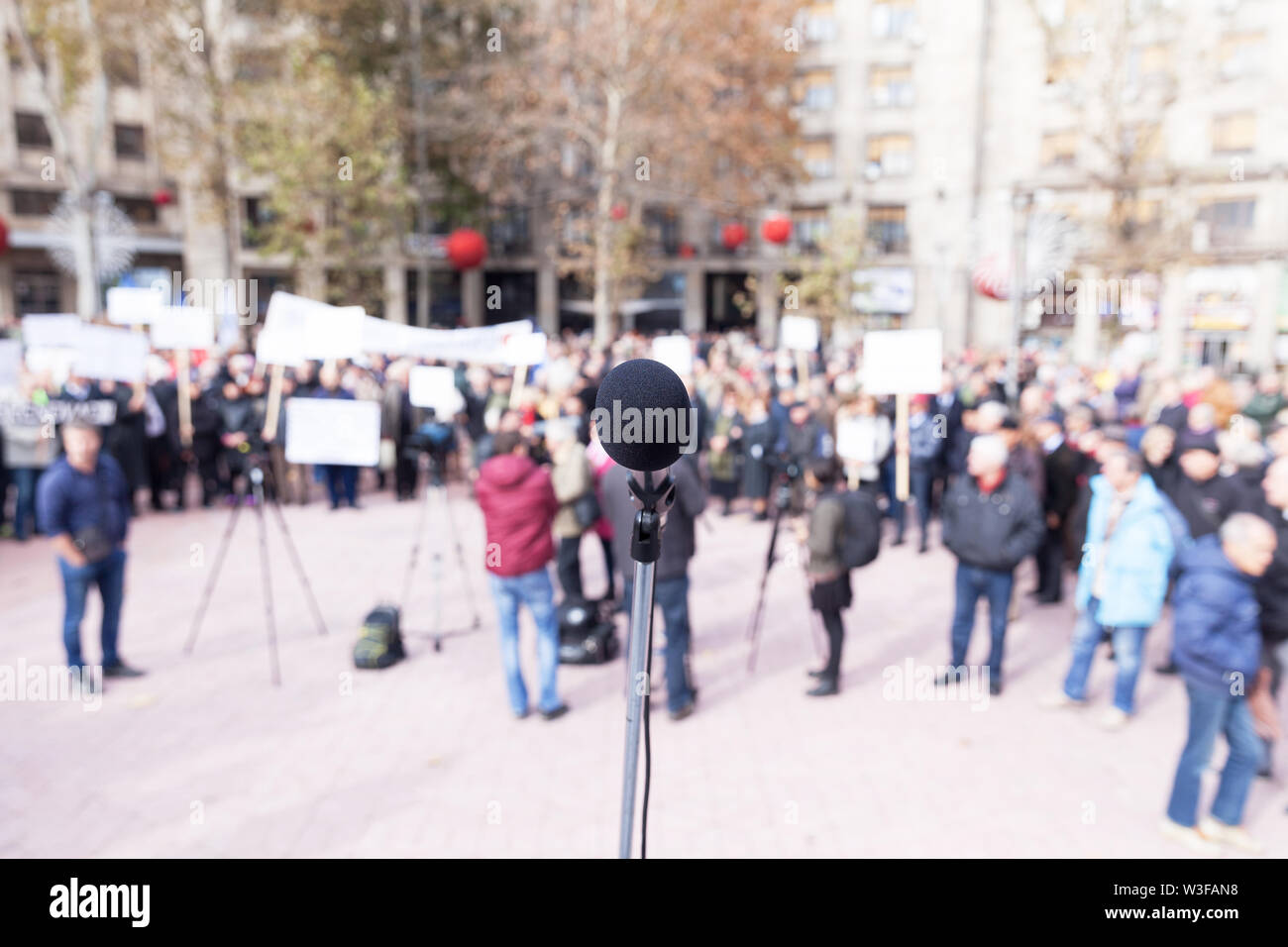 Microphone in focus against blurred protest or public demonstration ...