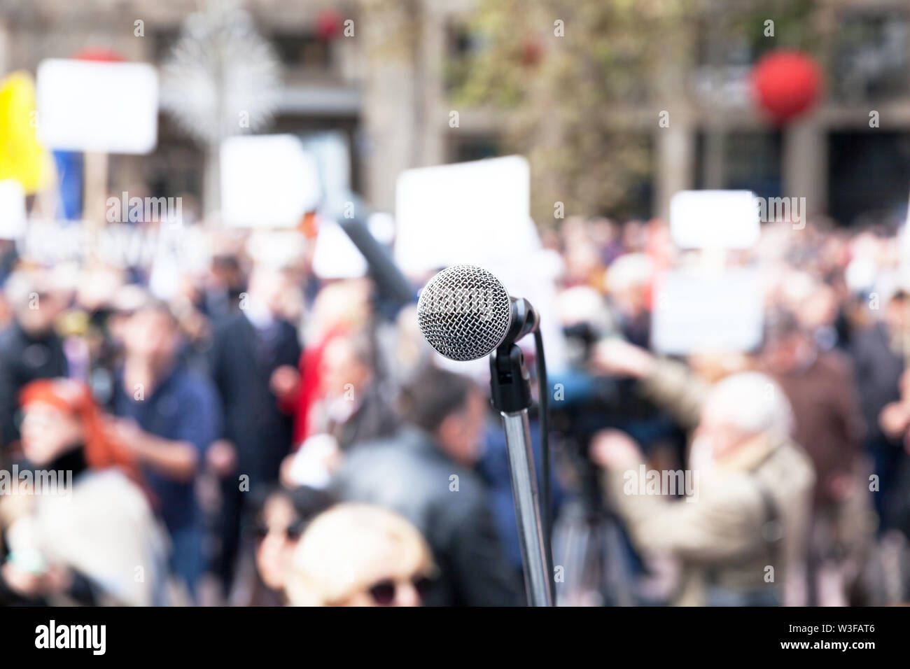 Microphone in focus against blurred protest or public demonstration ...