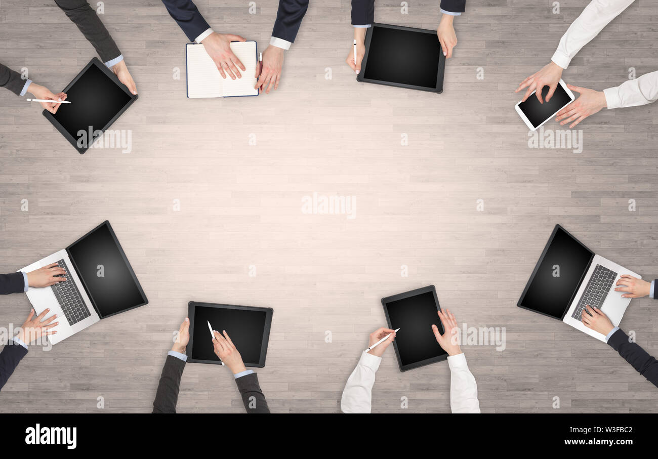 Group of people with devices in hands having desk discussion and making ...