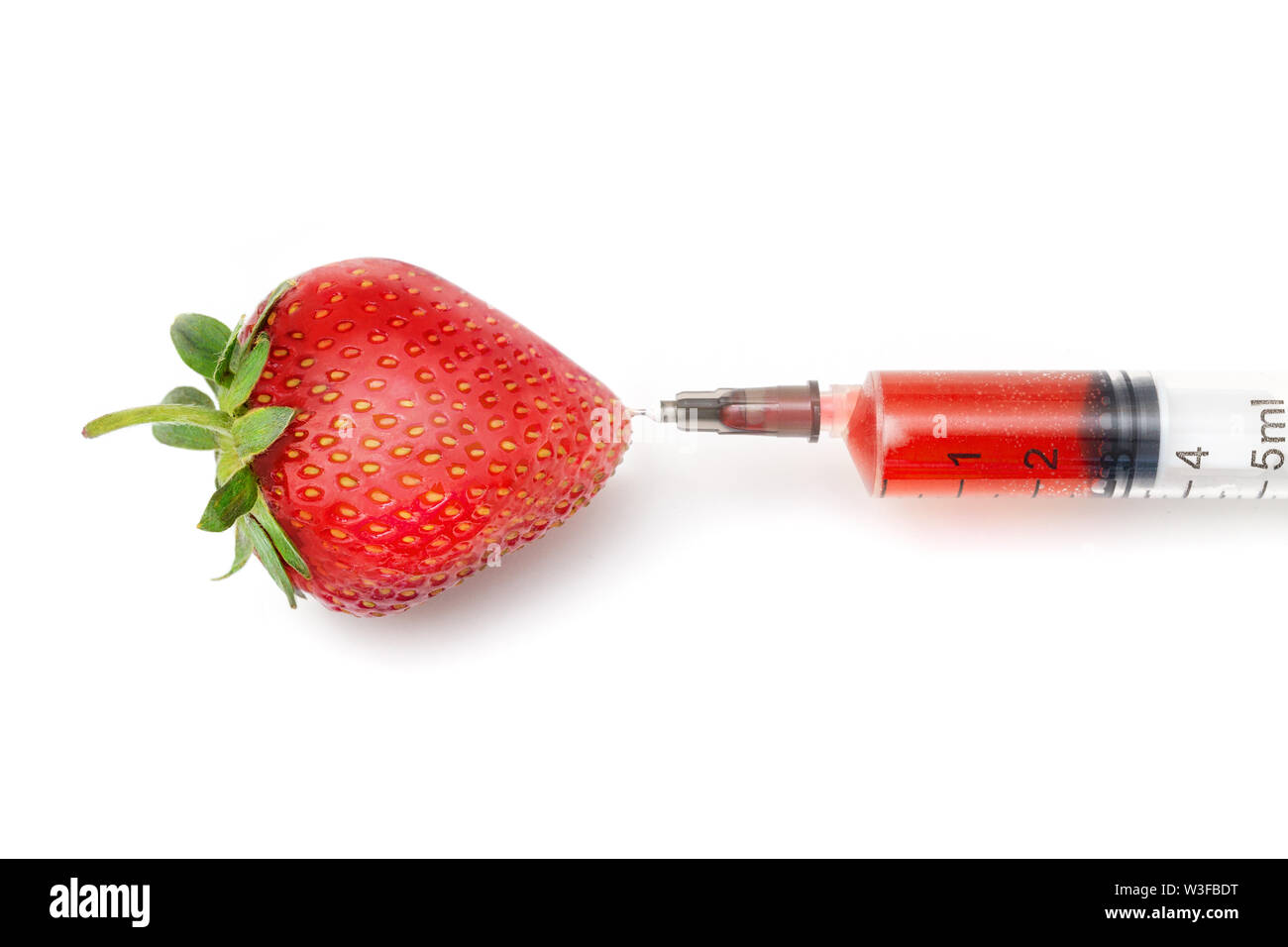 Strawberry and syringe with needle and juice inside. Closeup isolated ...