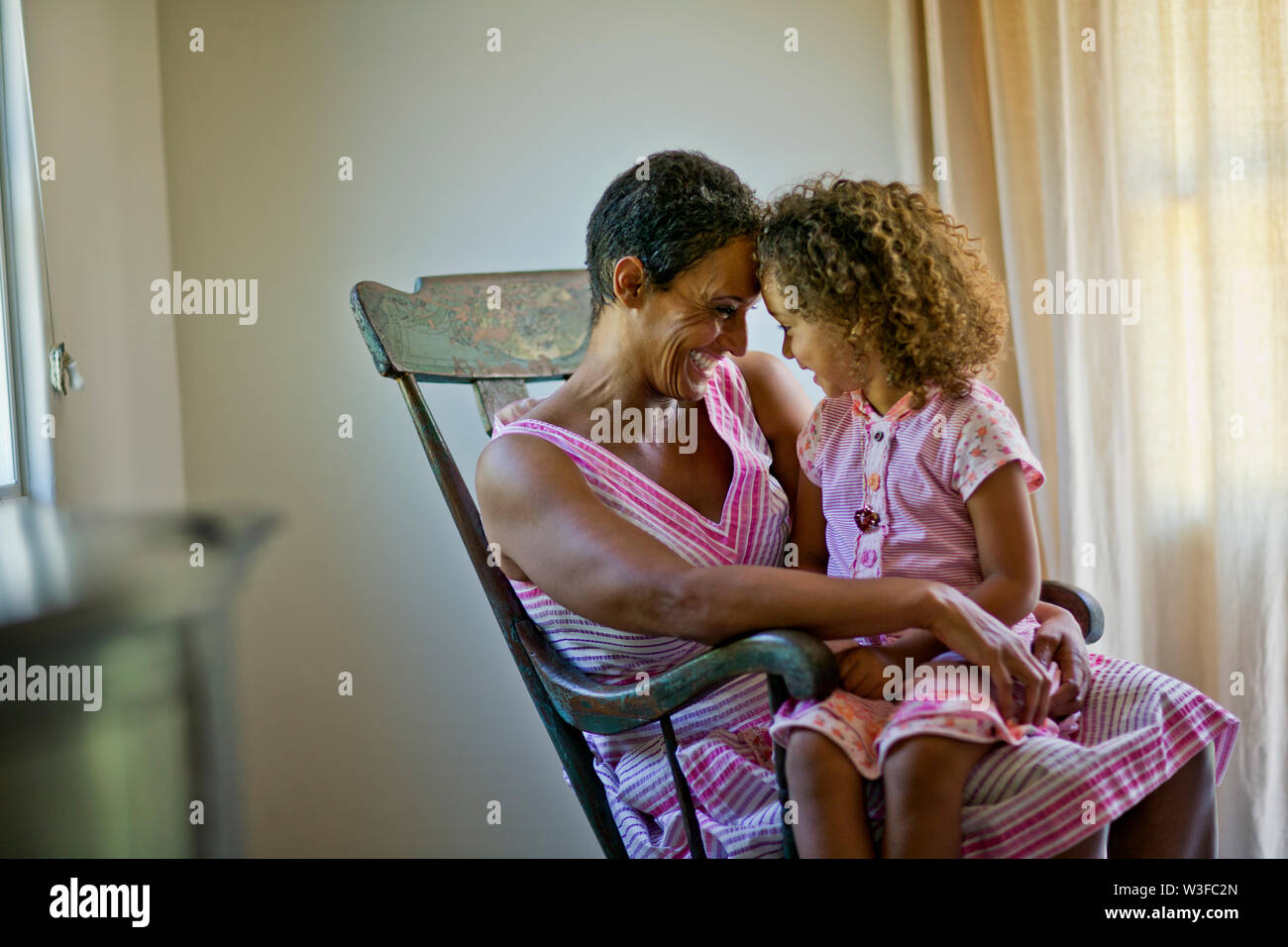 Mother and daughter sitting in a rocking chair Stock Photo - Alamy
