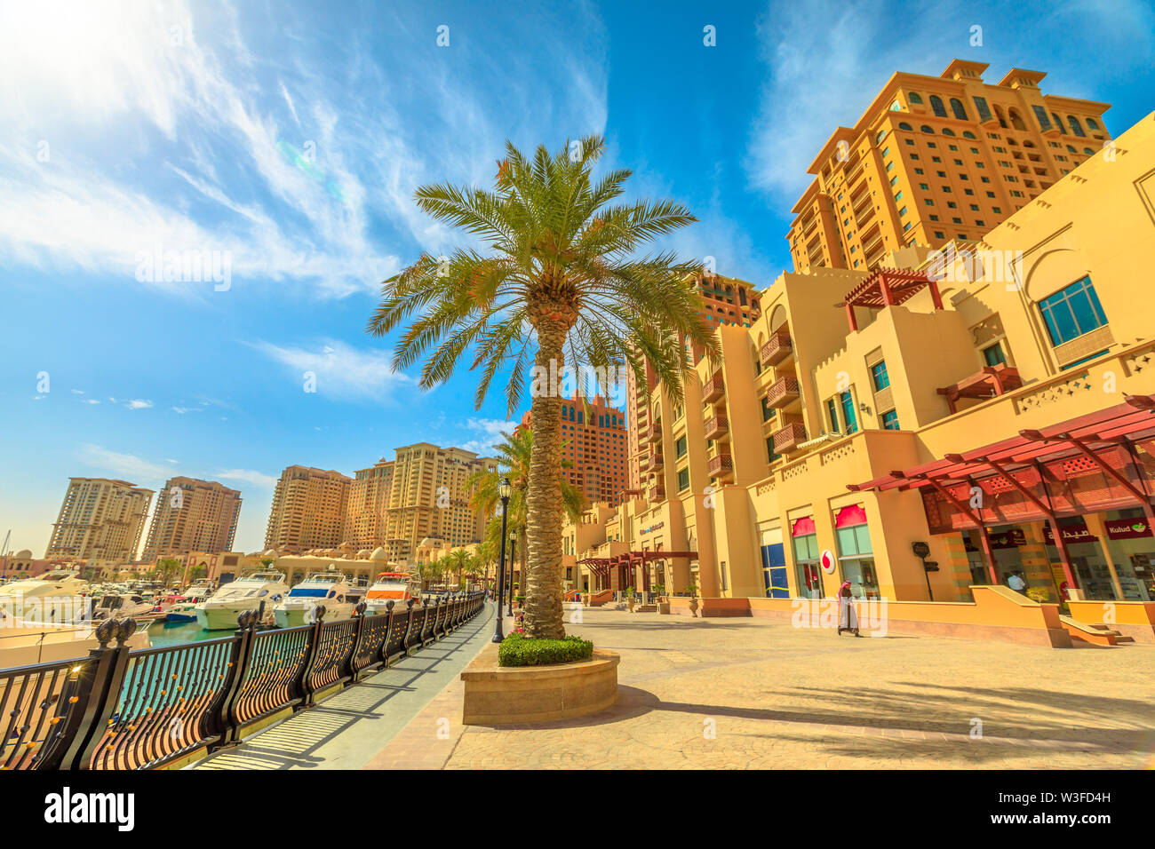 Doha, Qatar - February 18, 2019:Palm trees along luxury marina corniche ...