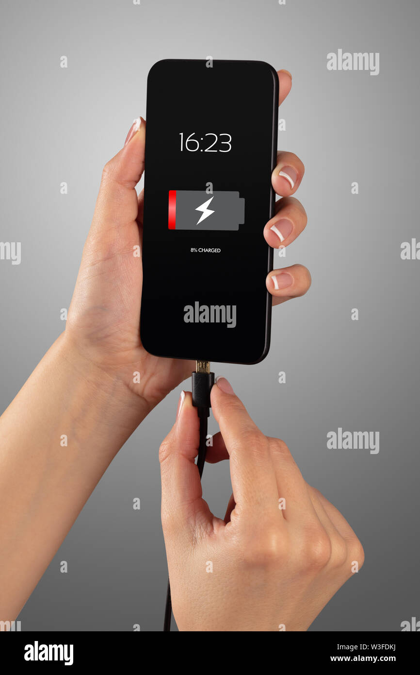 Elegant hand charging smartphone with low battery Stock Photo - Alamy