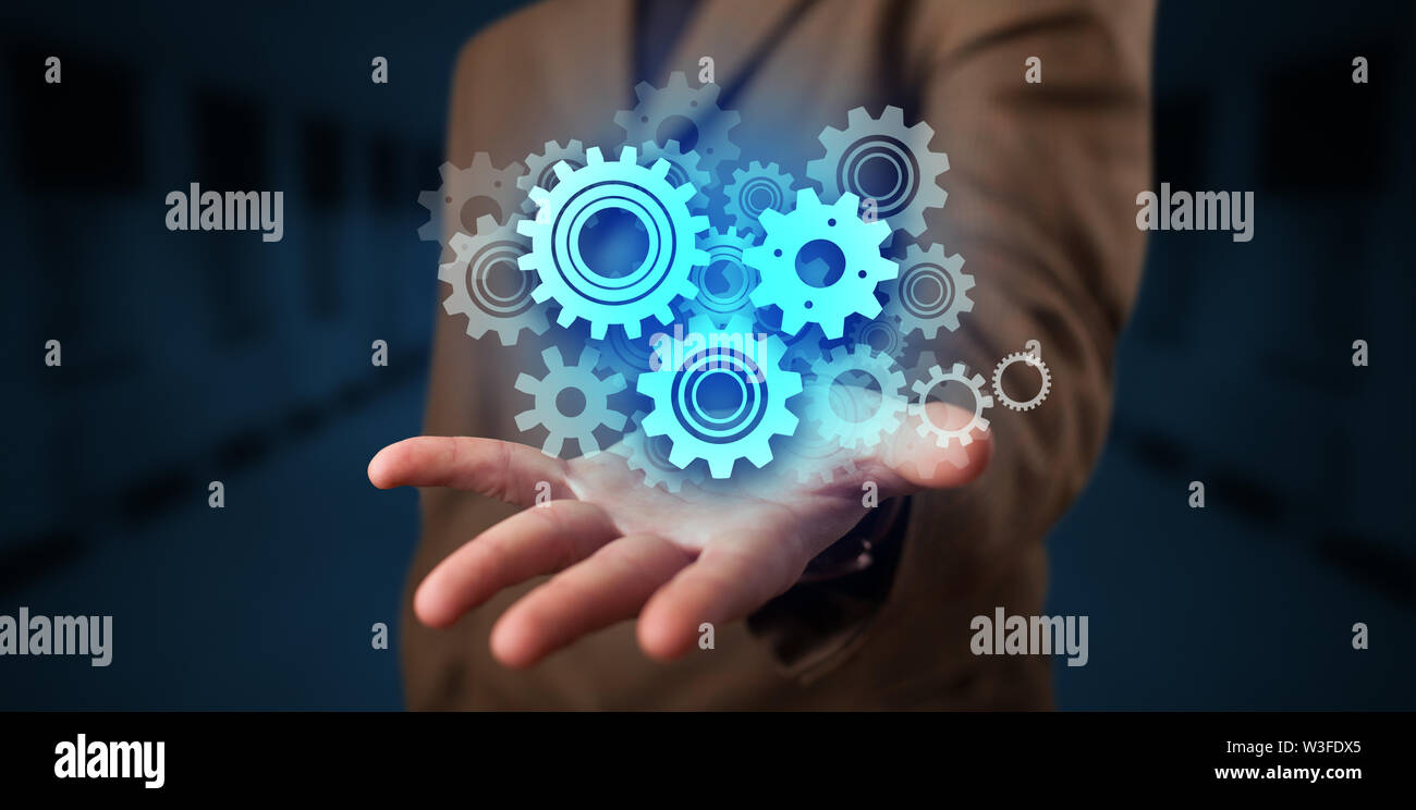 Hand holding gears in his hand Stock Photo - Alamy