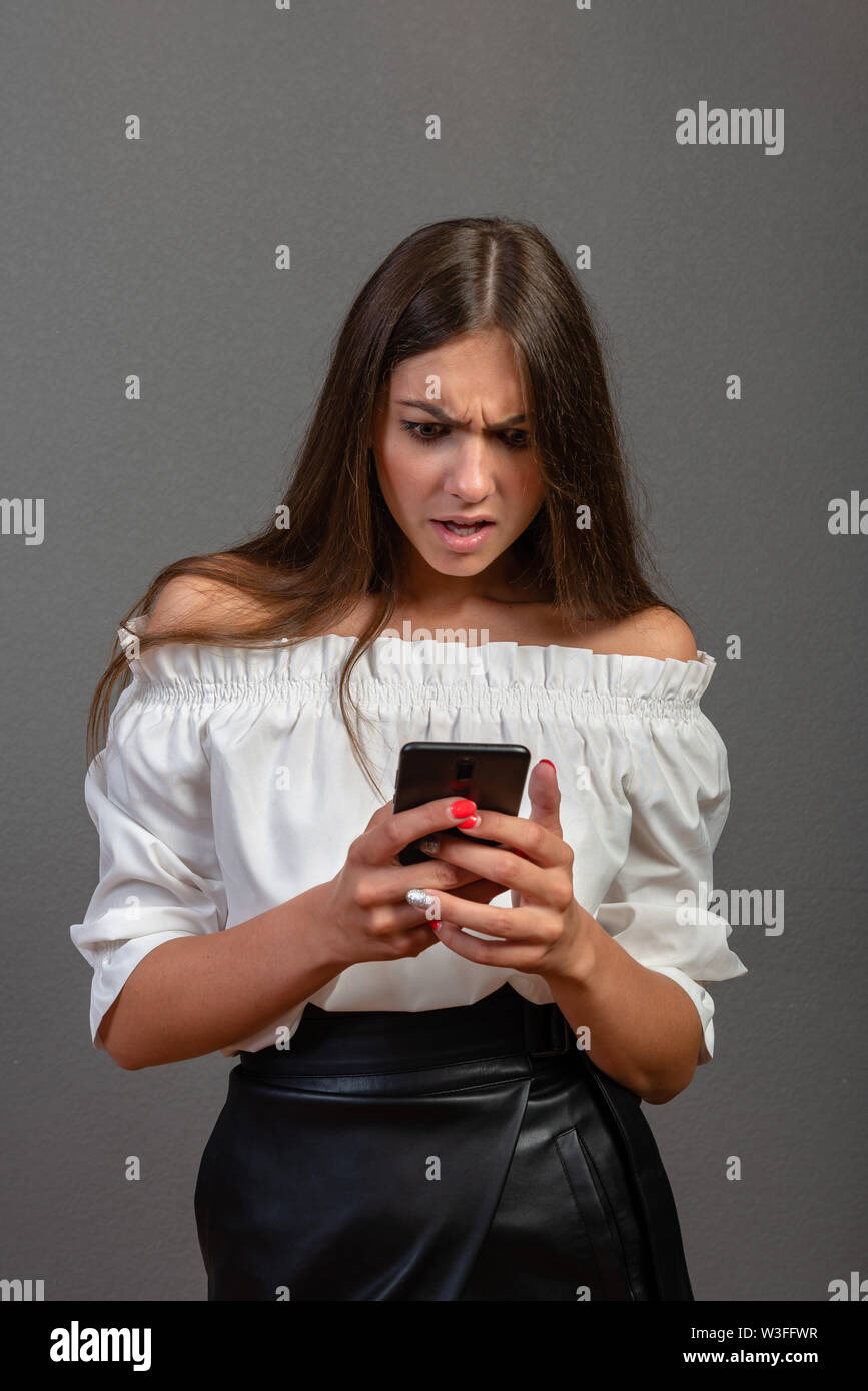 Photo of smiling woman with long dark hair holding and using black ...
