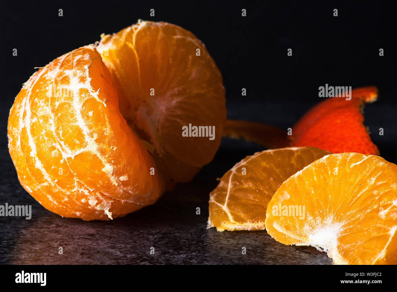 Peeled clementine with clementine segments and pieces of peel Stock ...