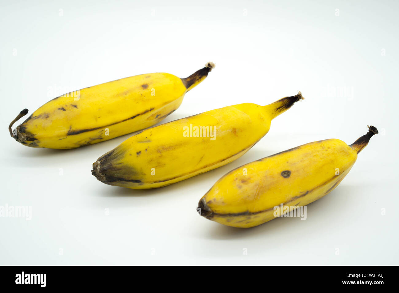 short bananas in a row isolated whiter background Stock Photo - Alamy