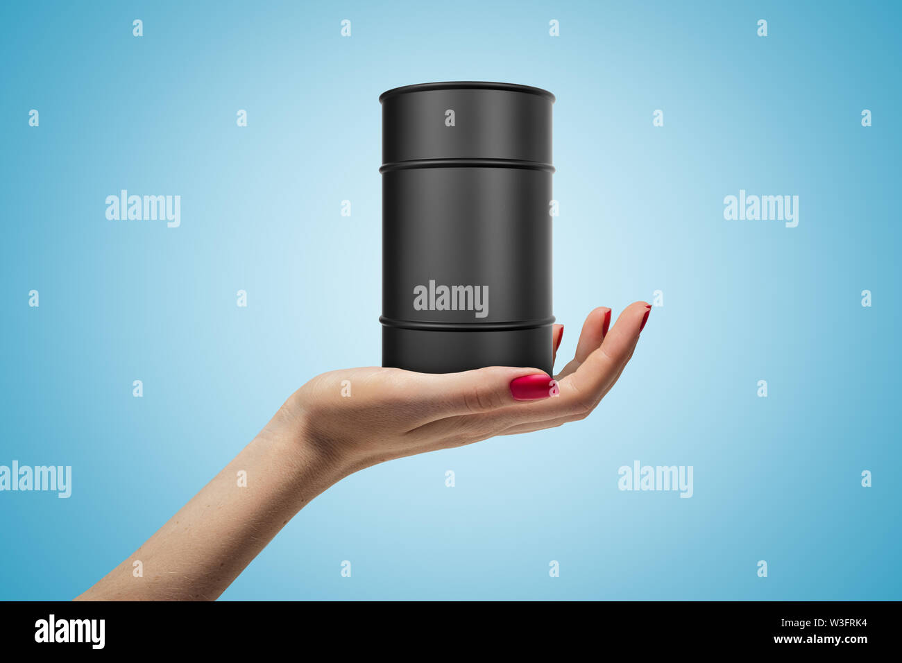 Female hand holding black oil barrel on blue background Stock Photo - Alamy