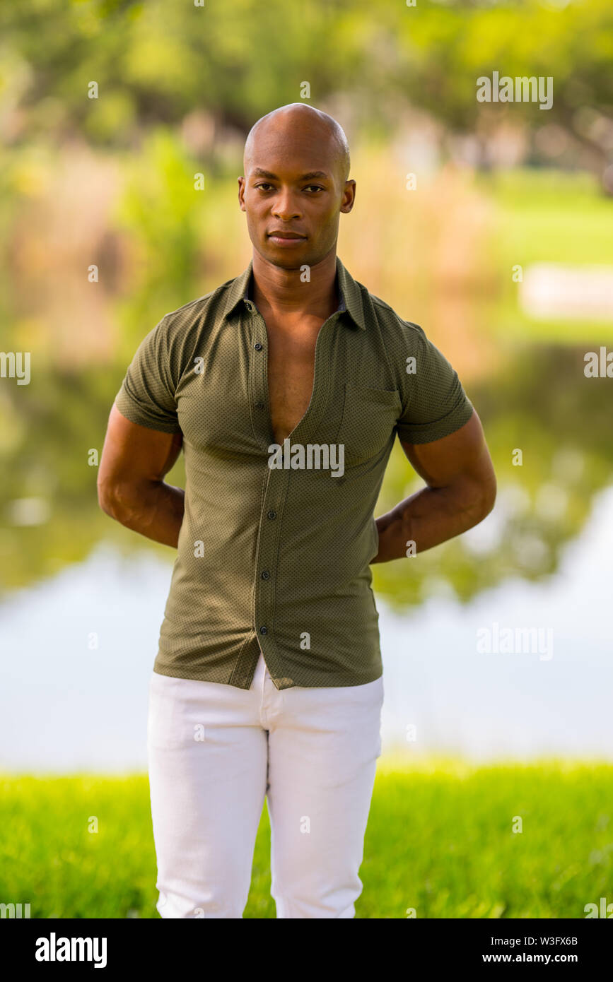 Photo of a handsome Black male model posing ith arms behind his back ...
