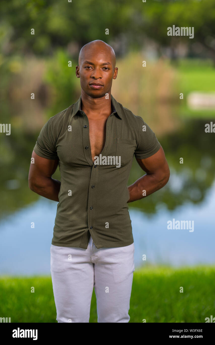 Portrait of a man posing with hands behind his back. Guy is wearing a ...
