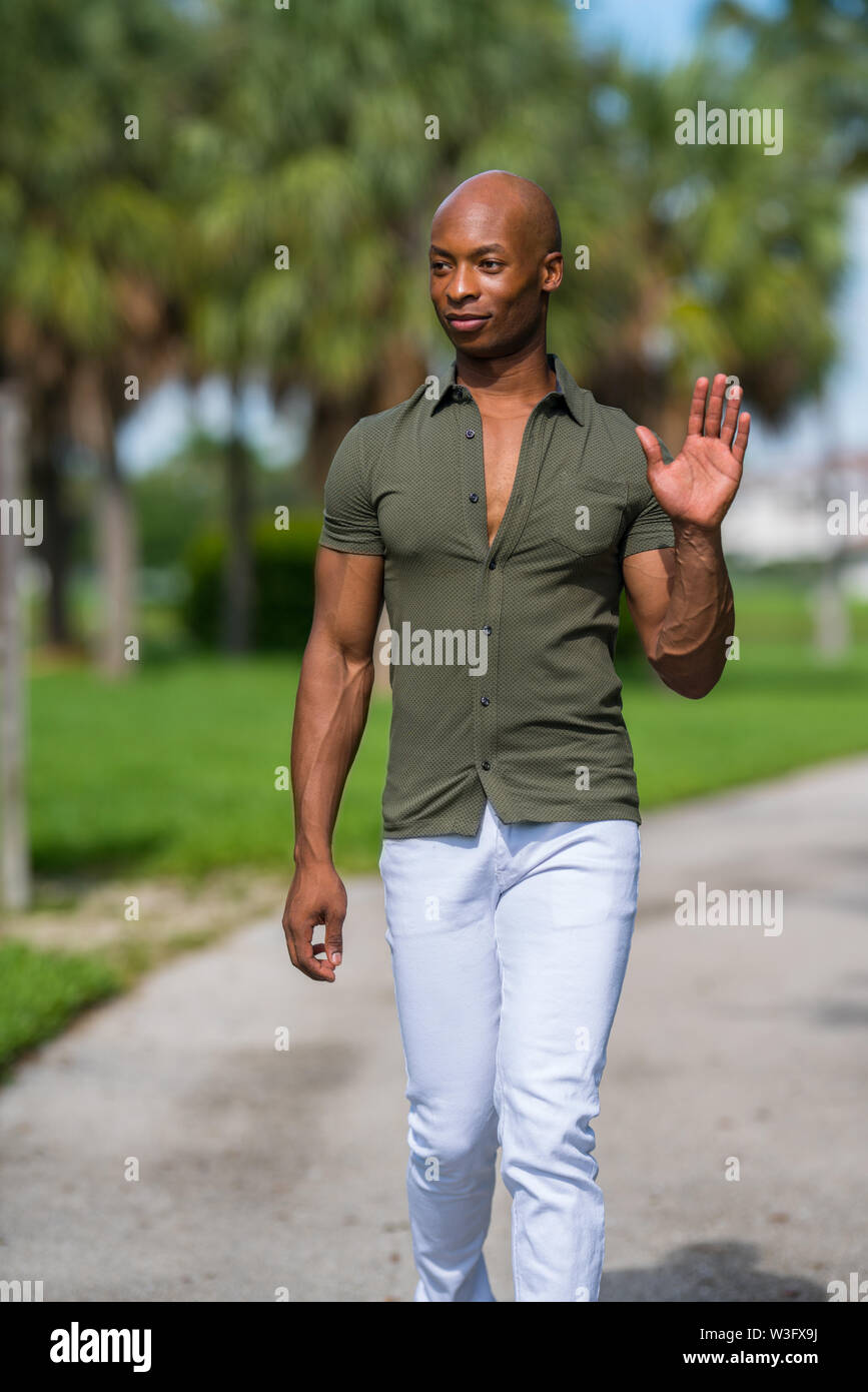 Portrait of a handsome man walking and waving hand off camera Stock ...