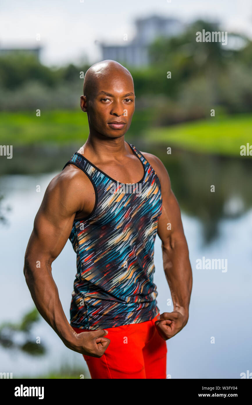 Portrait of an attractive man flexing his arms. Male model posing ...