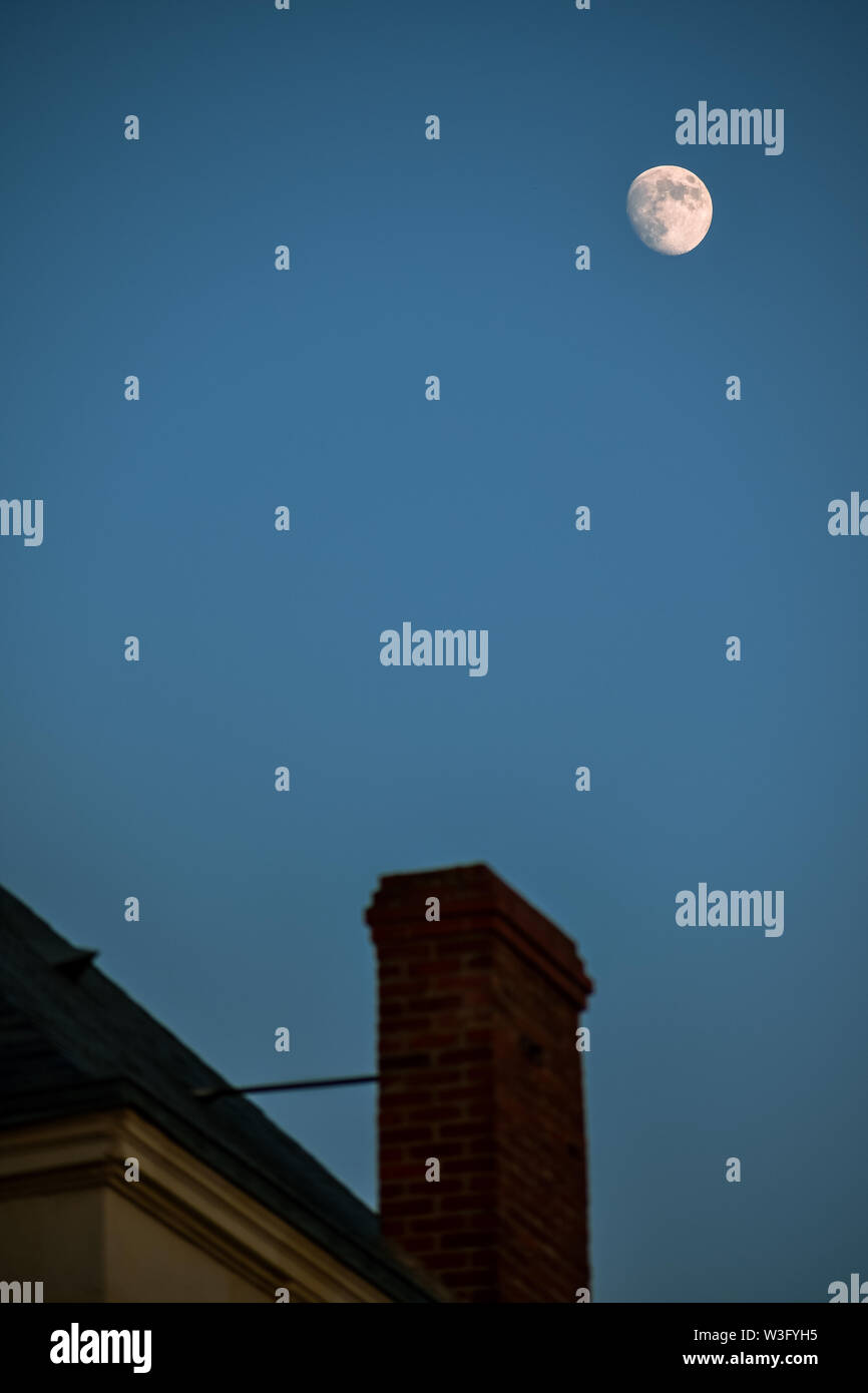 Chimney and roof unfocused, with the moon in the background. Concept of ...