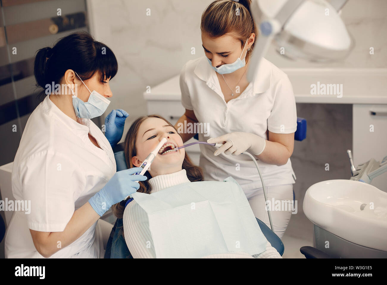 Beautiful girl sitting in the dentist's office Stock Photo - Alamy