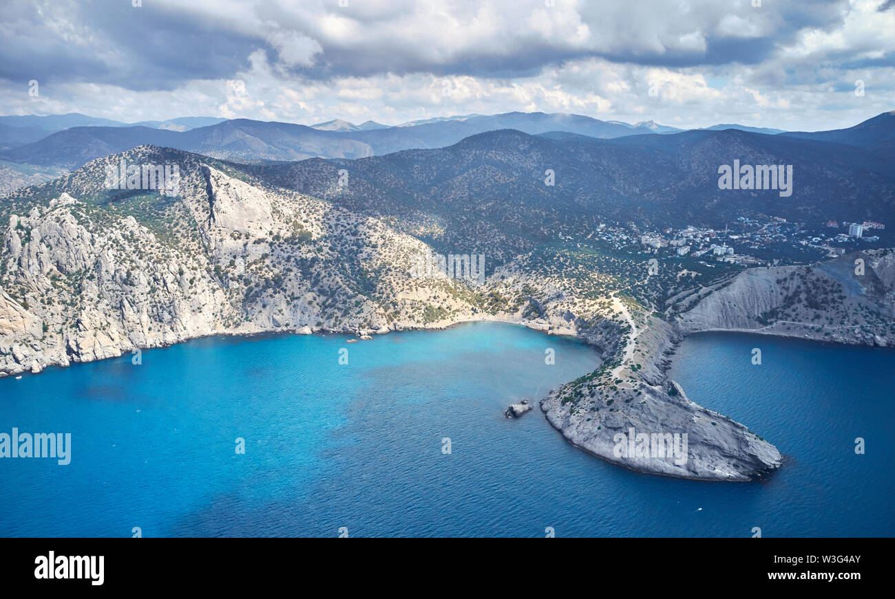 boat floats in the blue Bay at the rocks Stock Photo - Alamy
