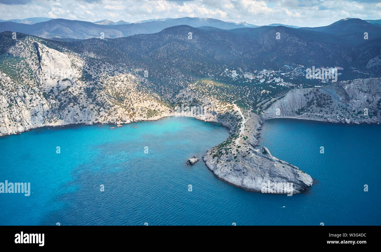 boat floats in the blue Bay at the rocks Stock Photo - Alamy