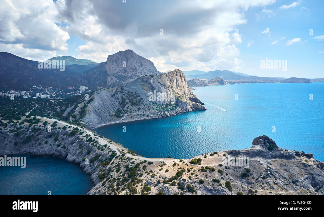 boat floats in the blue Bay at the rocks Stock Photo - Alamy