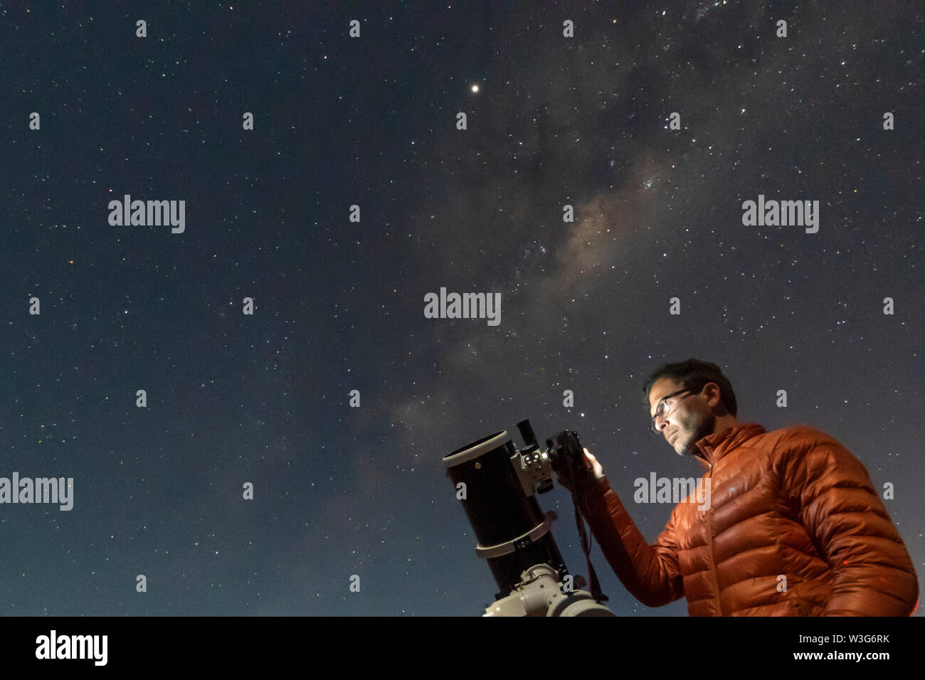 One astronomer man looking the night sky through an amateur telescope ...