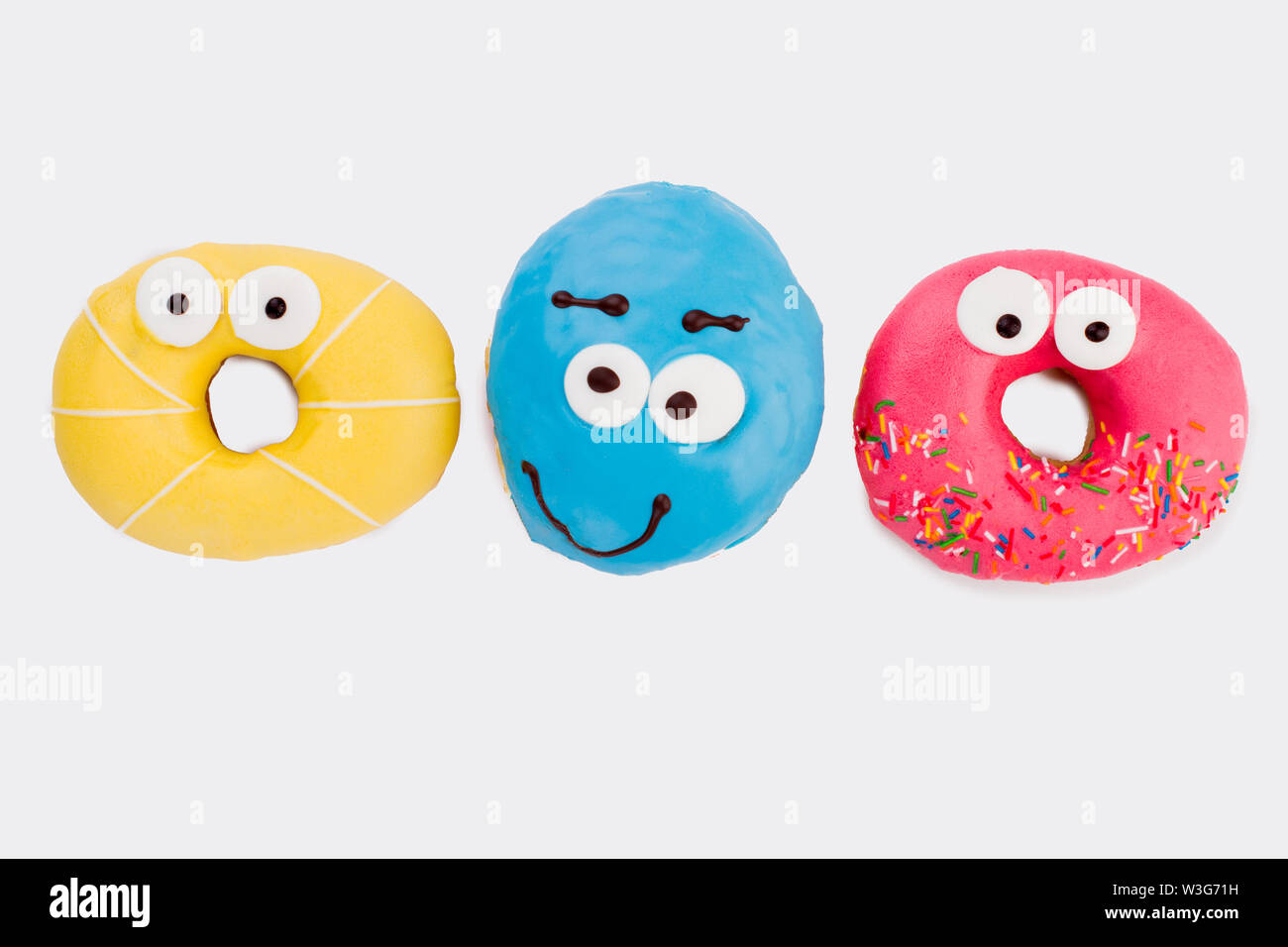 Three funny donuts on white background Stock Photo - Alamy