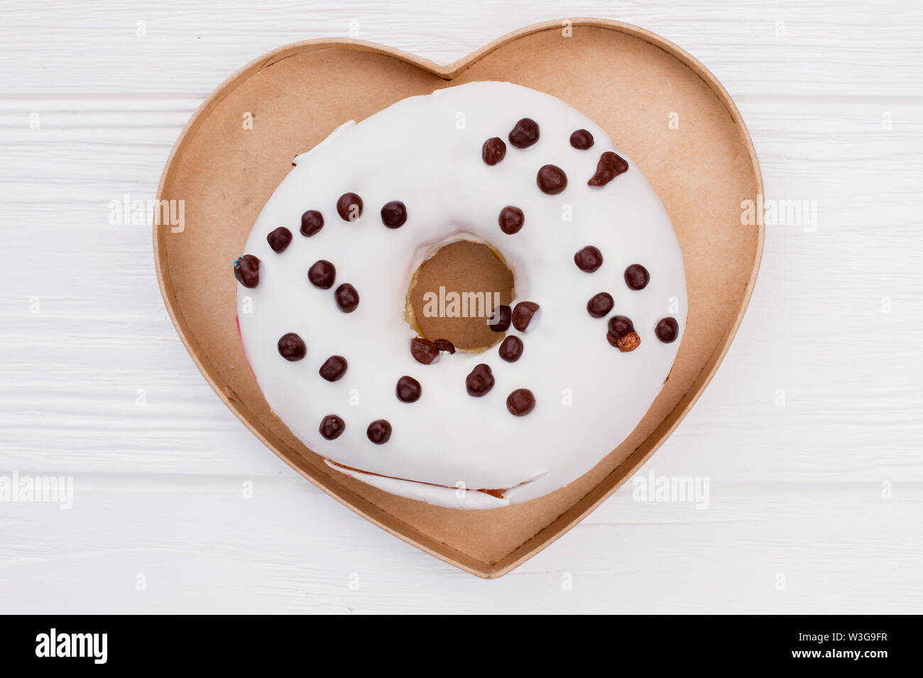 Heart-shaped box with iced donut Stock Photo - Alamy