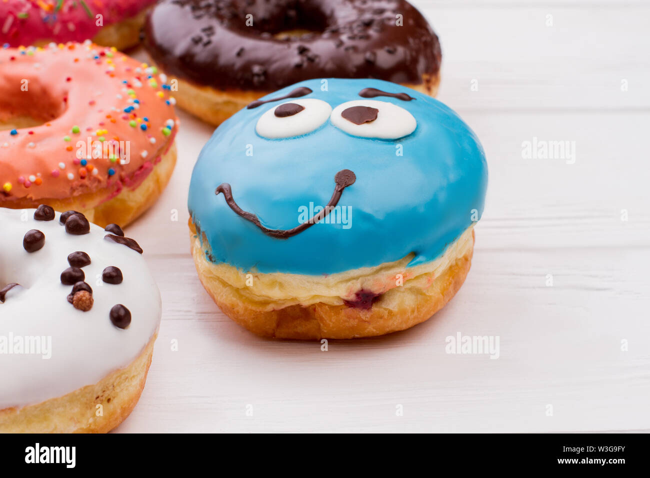 Blue funny donut on wooden table Stock Photo - Alamy