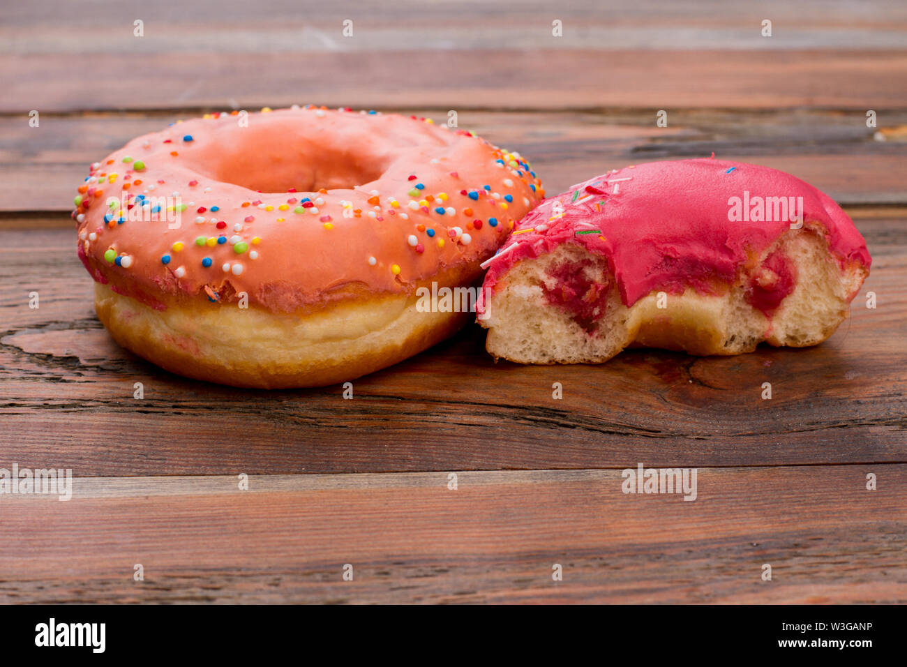 Whole and half on donuts on wooden background Stock Photo - Alamy