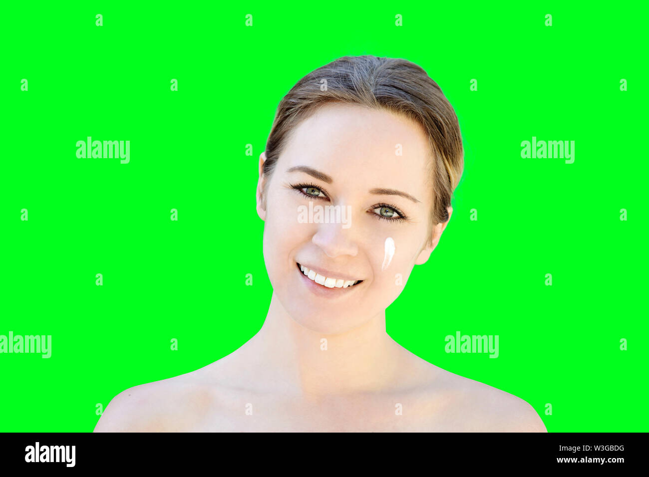 Beautiful female with white lotion smear on her cheek, smiles while on ...