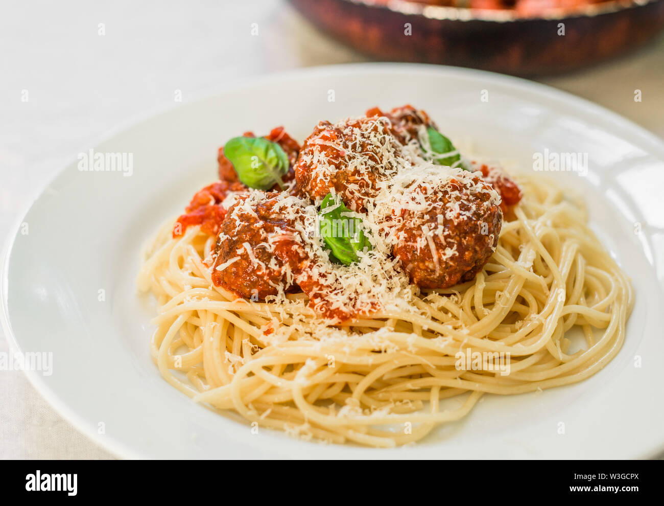 Spaghetti pasta with meatballs in tomato sauce, cheese falling over it ...