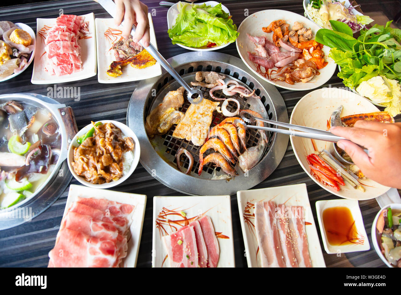 people eating barbecue beef in restaurant Stock Photo - Alamy