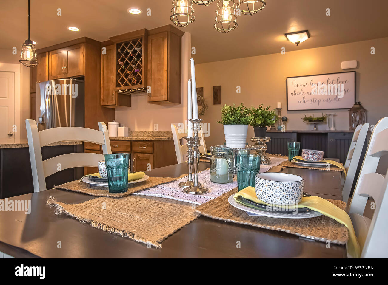 White chairs around a brown dining table with hemp table runners and ...